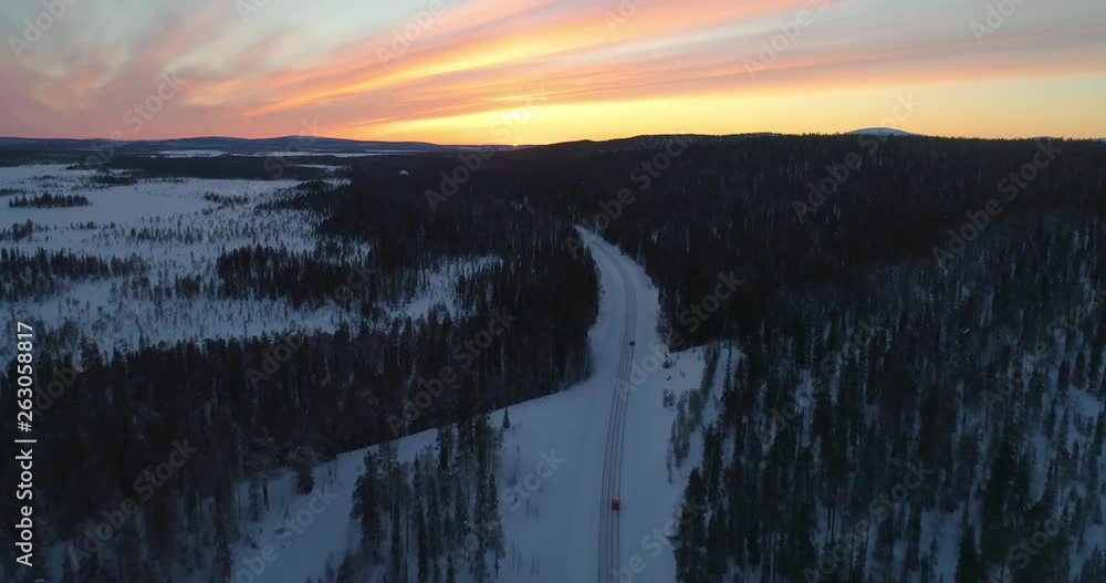 drone shot, following a vehicle, on a frozen route, between finnish ...