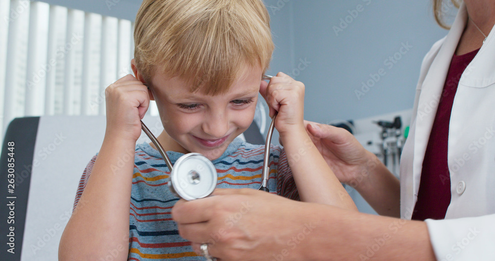 Foto de Female pediatrician letting little boy listen to stethoscope ...