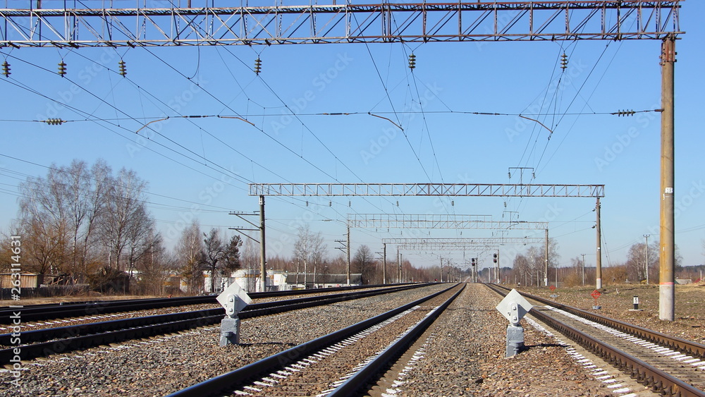 Broad gauge railway rails and contact wires in perspective on spring ...