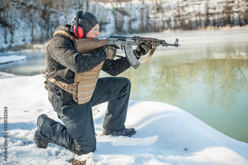 Army soldier in crouching position shooting from rifle machine gun ...