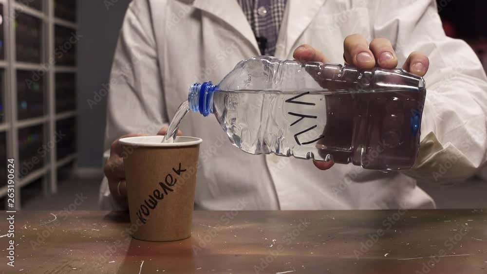 Vidéo Stock Male scientist dressed in white lab coat carefully pours ...