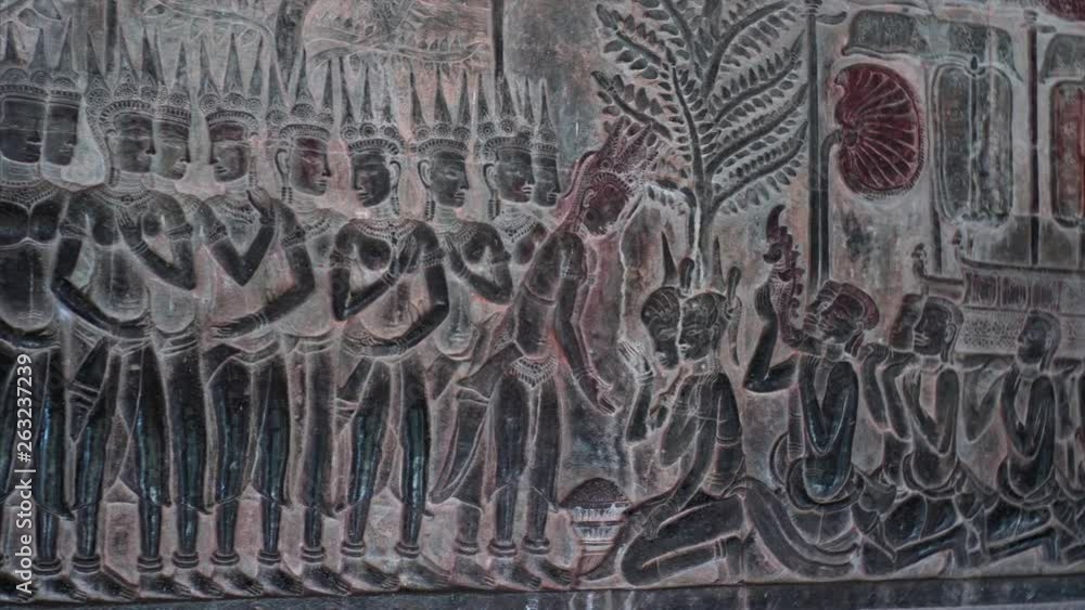 Close sliding view of beautiful ancient murals on the stone wall ...