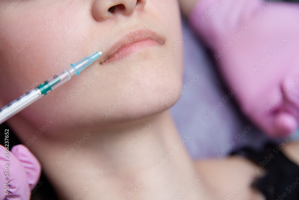 The doctor cosmetologist makes the Rejuvenating facial injections ...