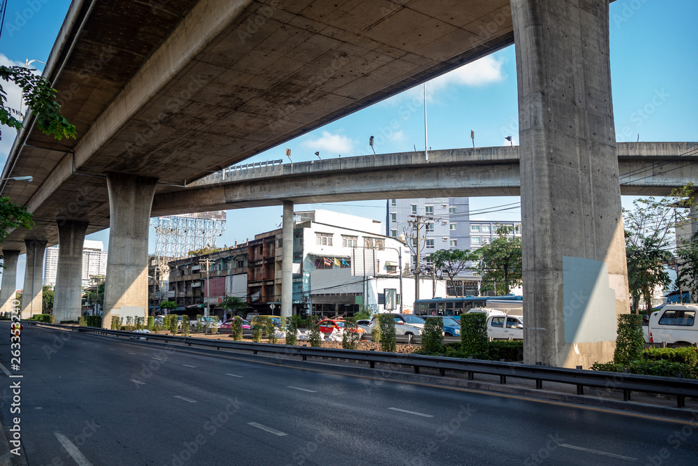 Traffic of the street under the expressway with houses and clear blue ...