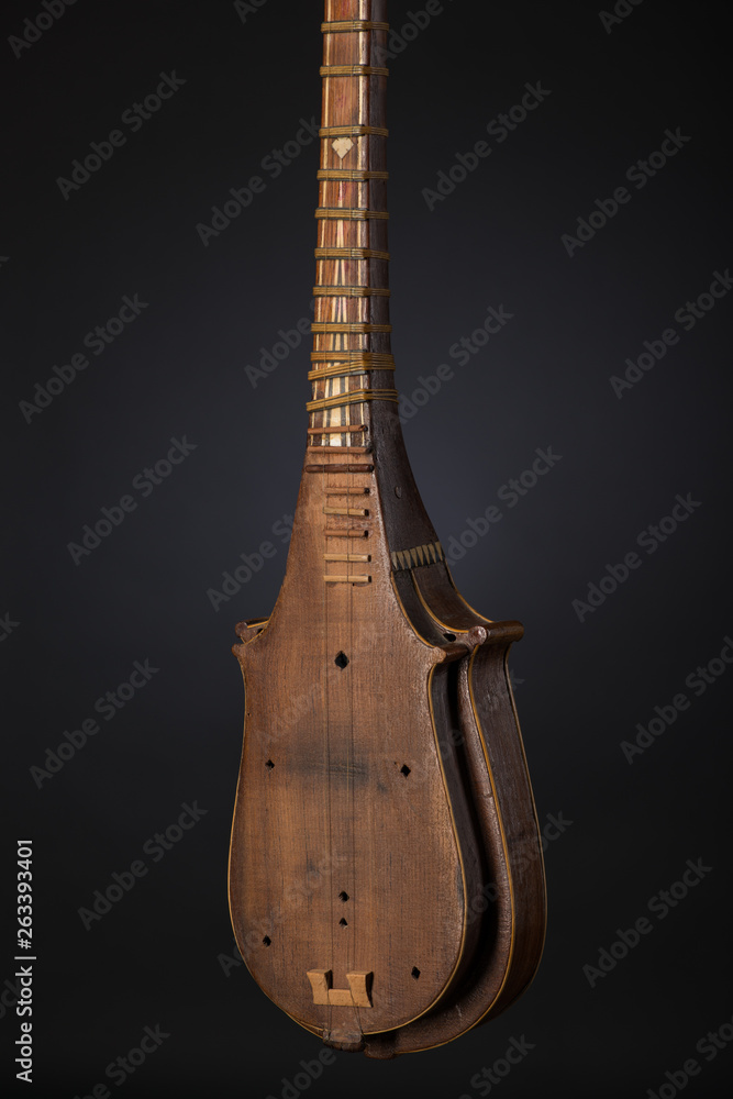 part ancient Asian stringed musical instrument on black background with ...