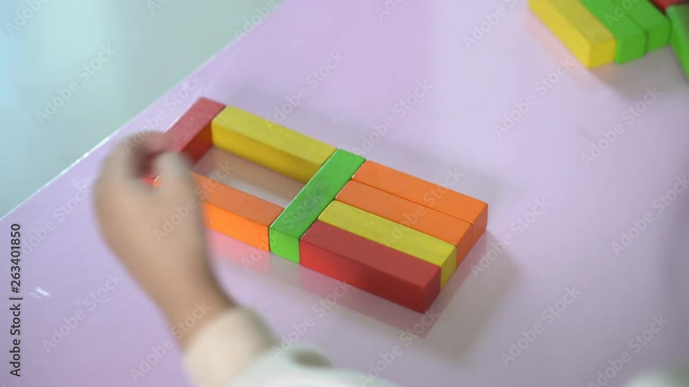 child or kid girl playing colorful wood block toy for practice using ...
