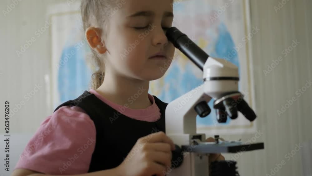 Little girl in science lab study samples under microscope. Schoolgirl ...