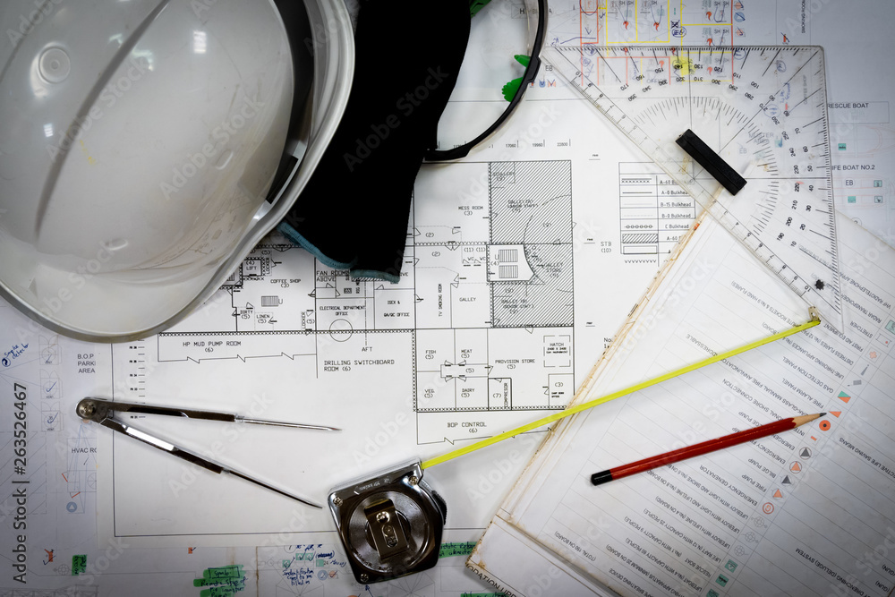 White safety helmet and drawing tools on naval architects working desk ...
