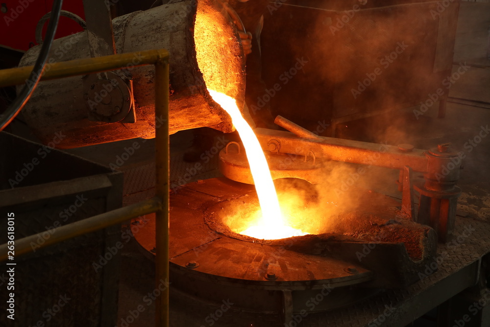 Molten iron pour from ladle into melting furnace Stock Photo | Adobe Stock