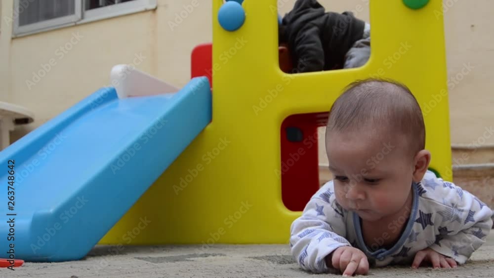 cute tree months old baby is having tummy time outside while his older ...