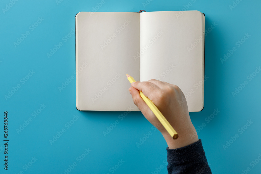Child hands holding a large spiral notepad with mockup for your design ...