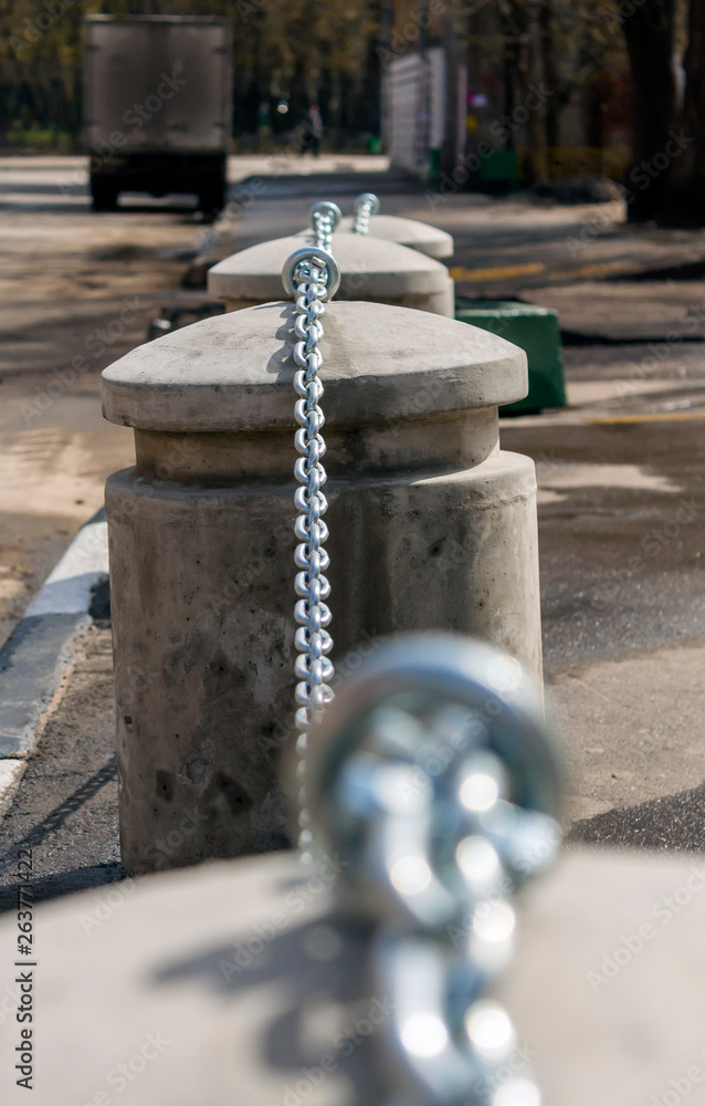 concrete fence in the form of concrete bollards with a chain along the ...