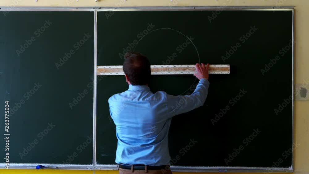 Math teacher draw a cross intersection with a ruler on a circle in a ...