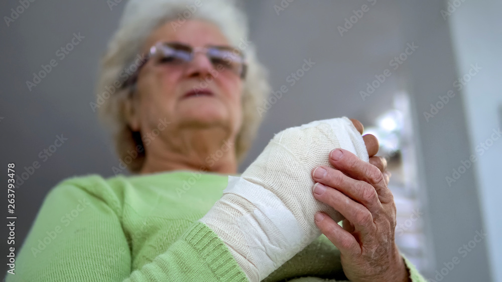 Old woman massage her injured broken hand sitting, cinematic dof Stock ...