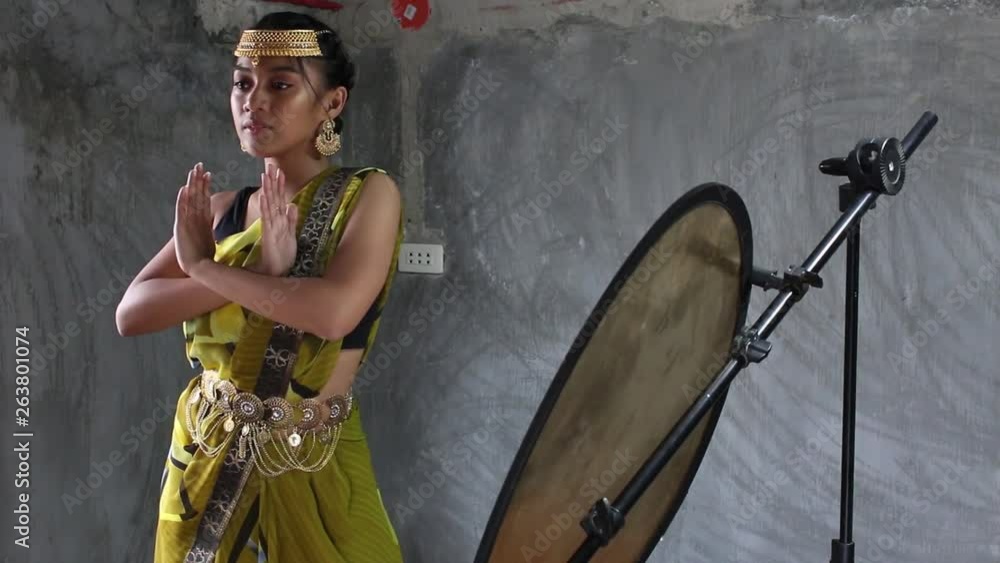 pretty asian young model dress up like an indian posing for a photoshoot inside a bare studio ...