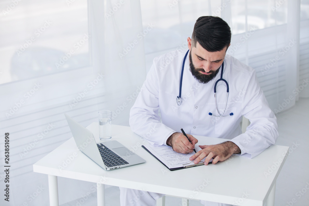 Doctor is working with documents and laptop in his medical office Stock ...