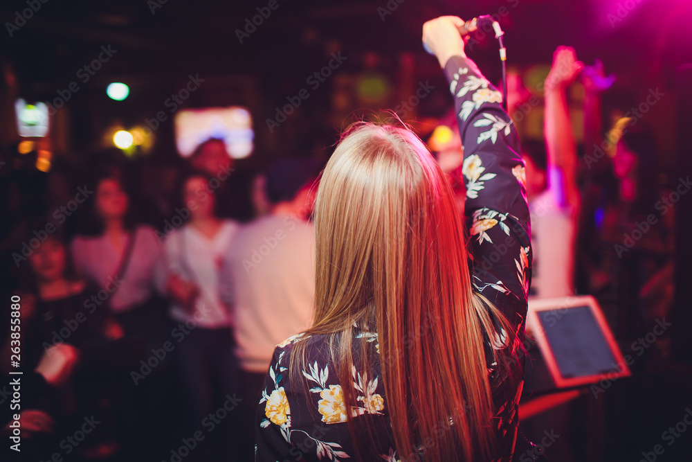 Beauty model girl singer with a microphone singing and dancing over ...
