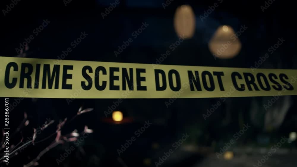 Close-up of crime scene tape as the camera tracks to the right. Lights ...