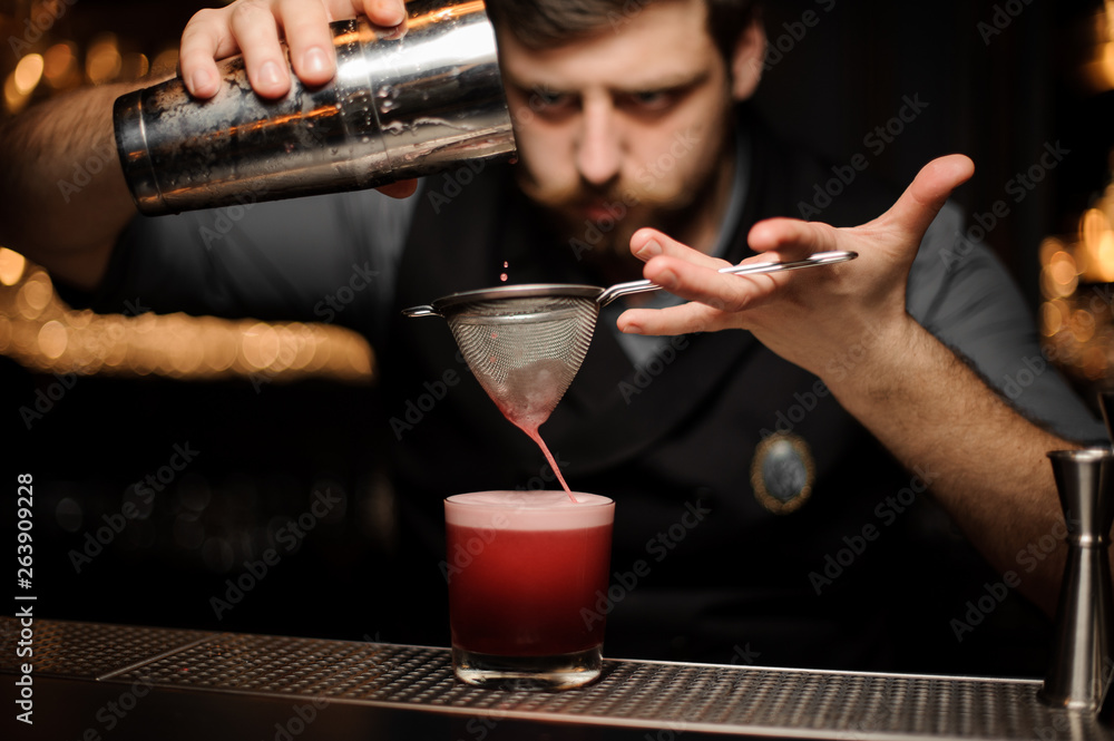 Bartender making alcohol drink using shaker and sieve Stock Photo ...