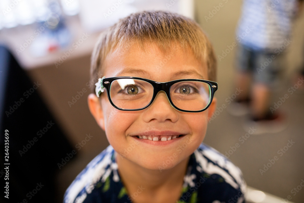 Elementary age boy excited to be wearing glasses in doctors office ...