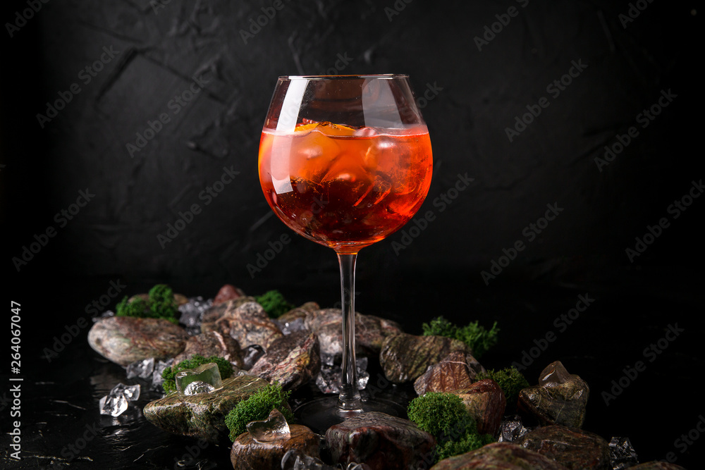 Aperol syringe soft alcoholic drink on a black background with stones ...