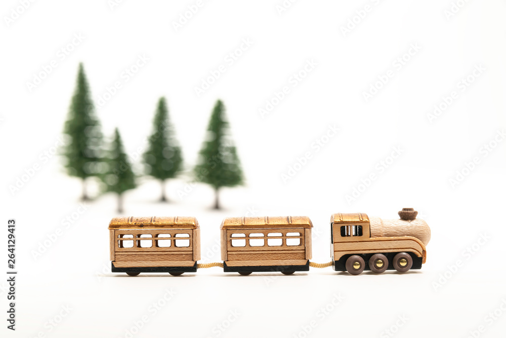 Golden wooden toy train isolated from white background and blur pine ...
