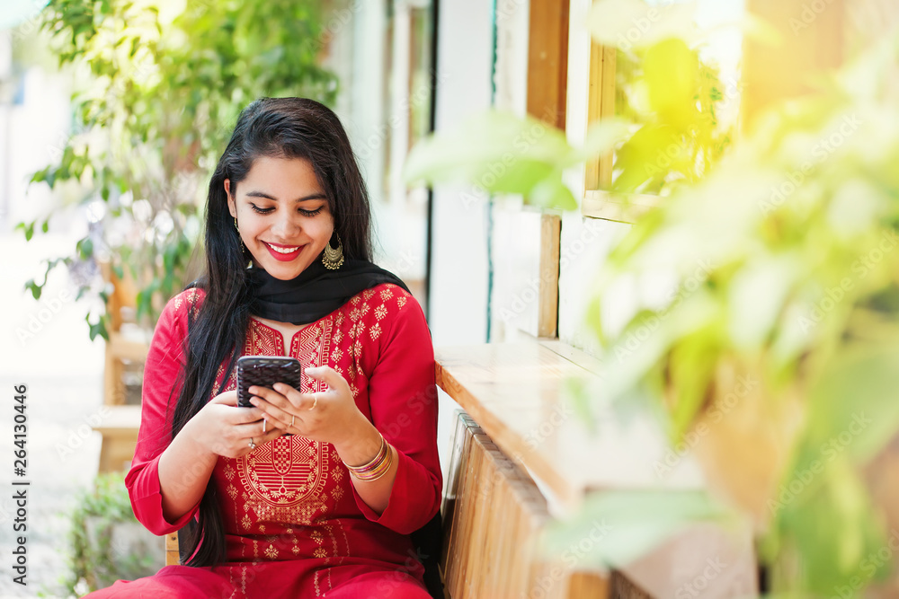 Pretty young indian woman using her phone Stock Photo | Adobe Stock