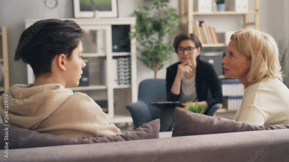Mature lady discussing relationship with teenage son while psychologist ...