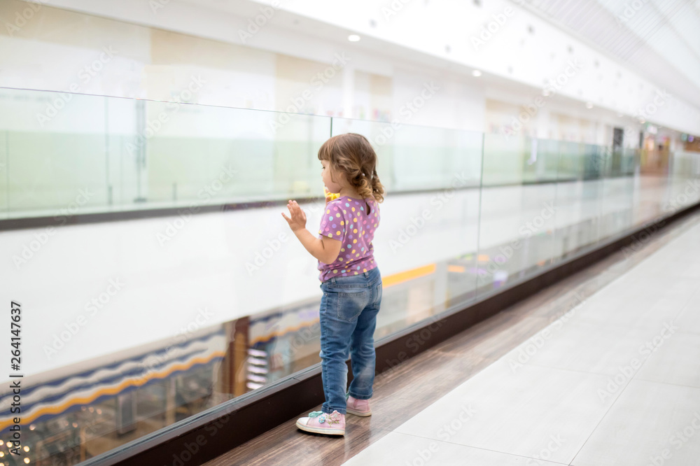 Little girl alone in shopping mall center, looking for her mother. The ... Little girl alone in shopping mall center, looking for her mother. The ...