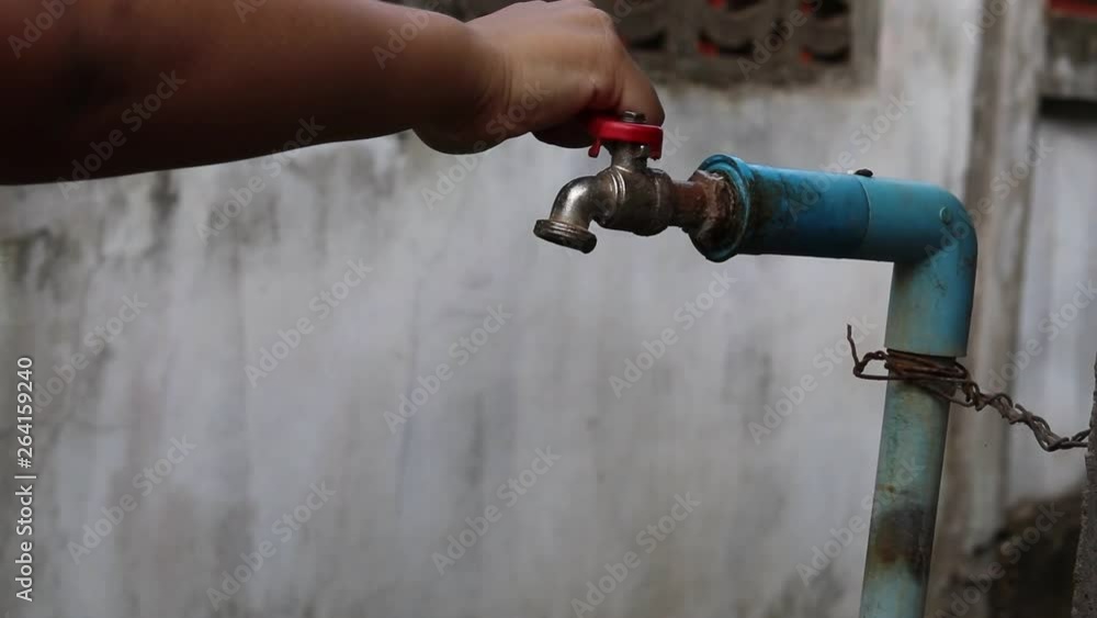Stockvideo Young hand is turning off slow flowing old water tap to save ...