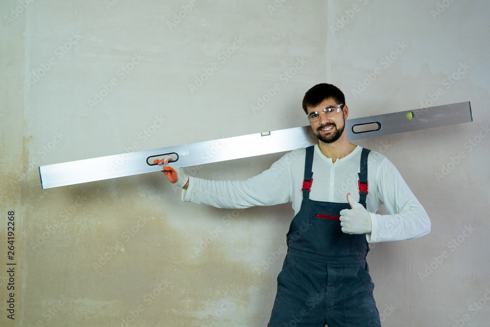 smiling builder with construction ruler shows thumb up in interior free ...