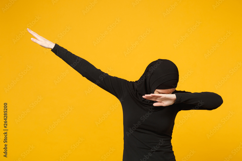 Young teen arabian muslim woman in hijab black clothes doing dab dance ...