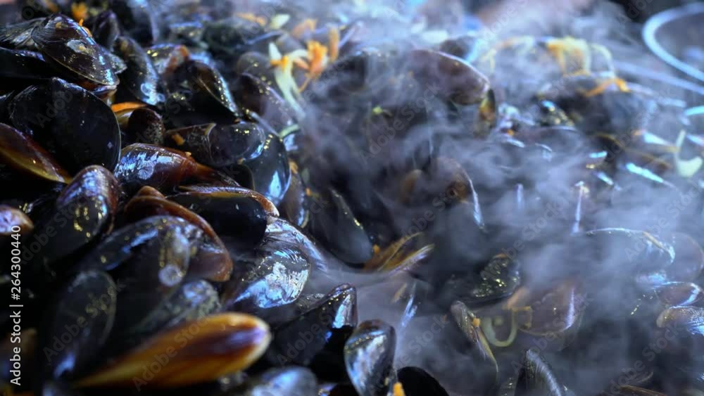 Mussels in the shell. Cook fries mussels in a large frying pan. Seafood ...