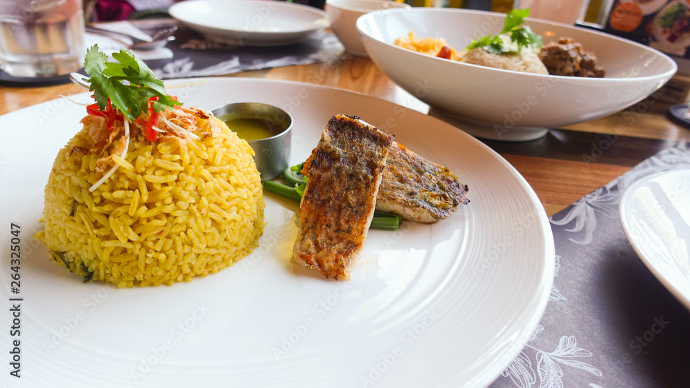 Muslim yellow rice with fish or Biryani with green chutney in white ...