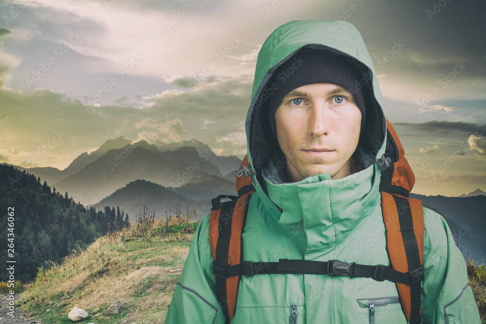 Young male hiker on cloudy landscape background looking at camera ...