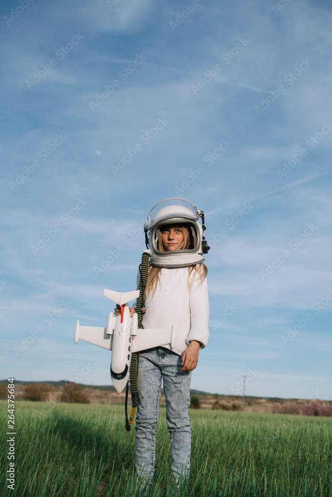 Adorable little girl wearing a helmet and playing alone with a space ...