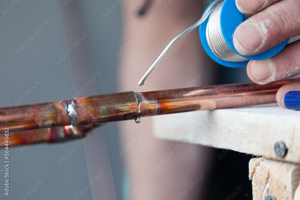 Closeup professional master plumber holding flux paste for soldering ...