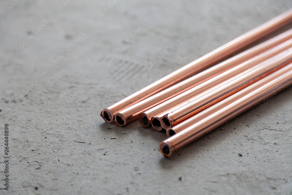 Close-up many new copper dyne pipes on the concrete floor. Concept ...