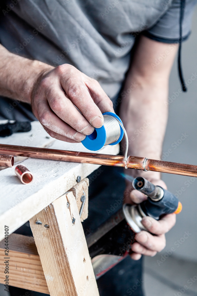 Closeup professional master plumber holding flux paste for soldering ...