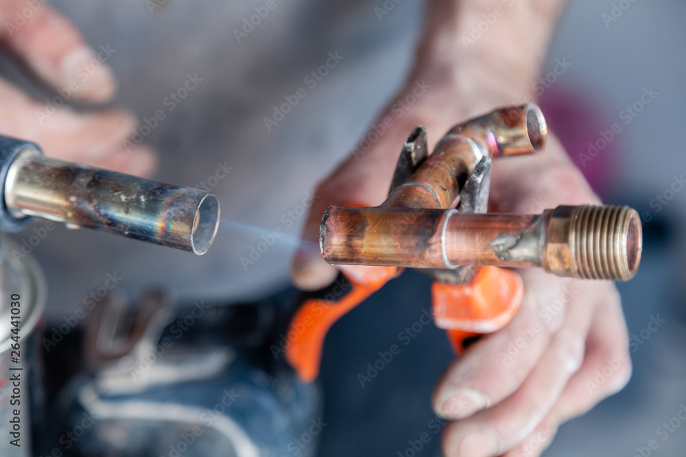 Closeup professional master plumber holding flux paste for soldering ...