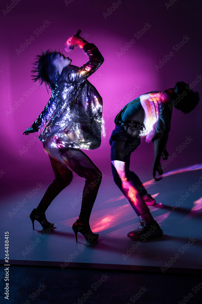 Side view of young singing lady and dancing man performing on stage ...