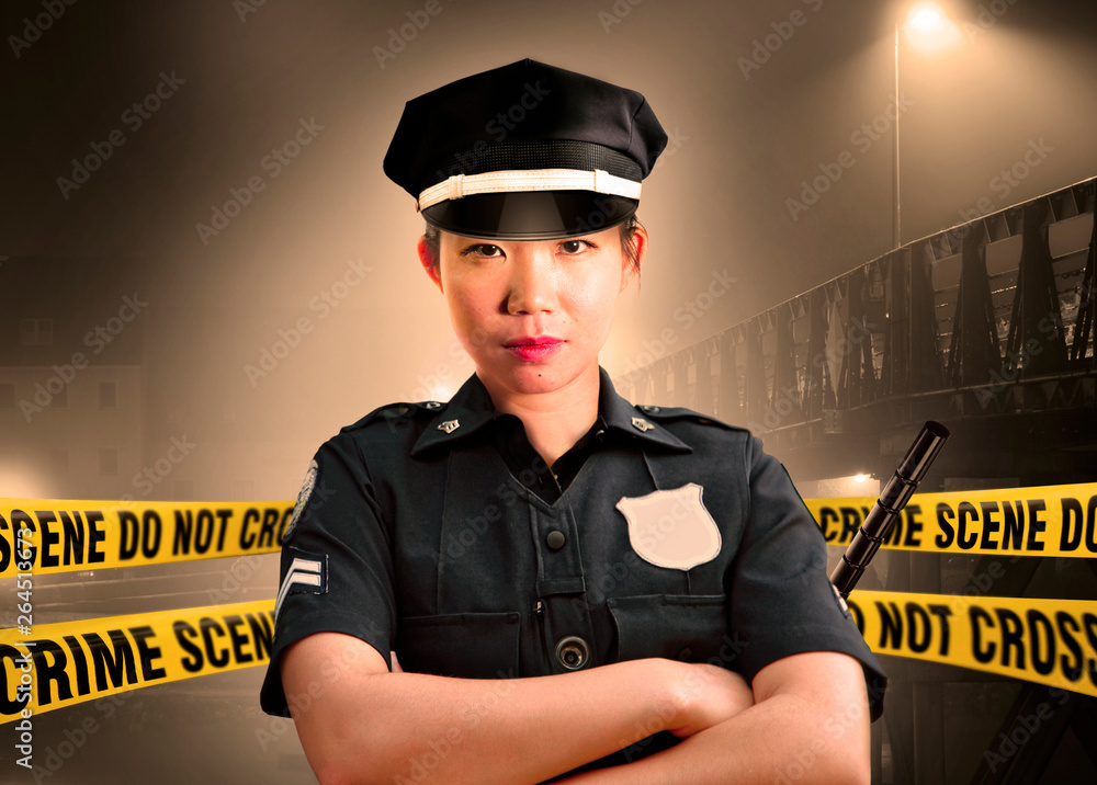 young Asian American police officer standing serious in custody of ...