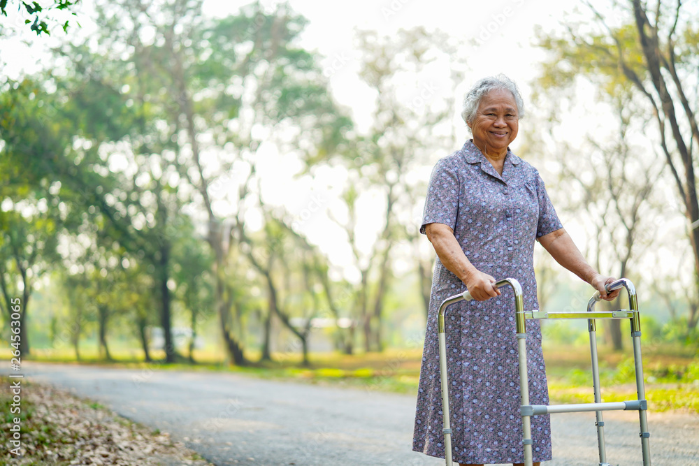 Asian senior or elderly old lady woman patient walk with walker in park ...