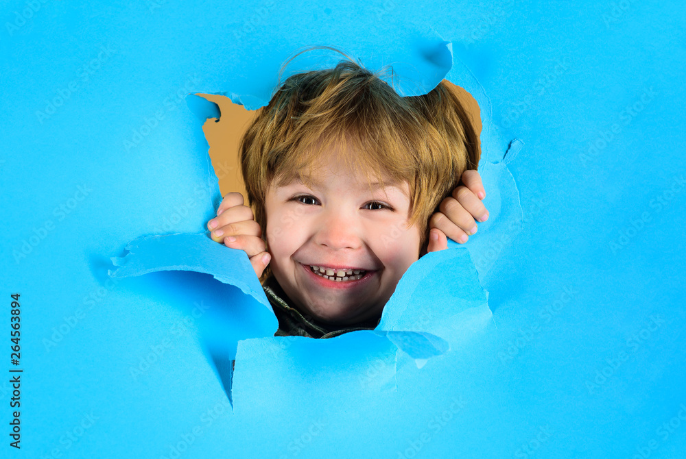 Through paper. Happy child. Child looking through paper. Happy kid. Boy ...