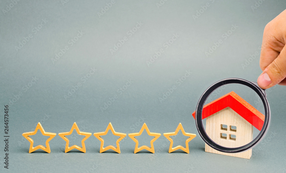 Five stars and a wooden house on a gray background. The concept of the ...