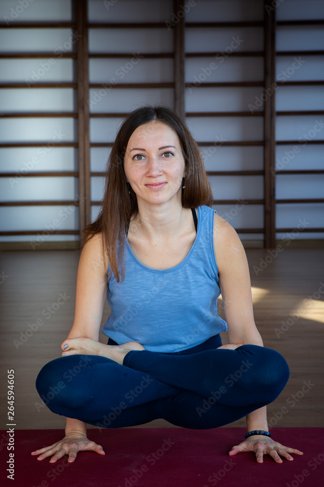 Beautiful young woman working out in loft interior, doing yoga exercise ...