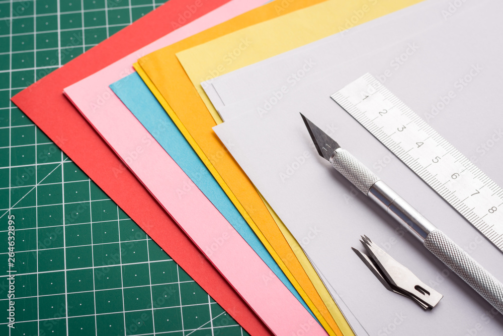 Ruler, scalpel and kit of blades on coloured papers on the table Stock ...