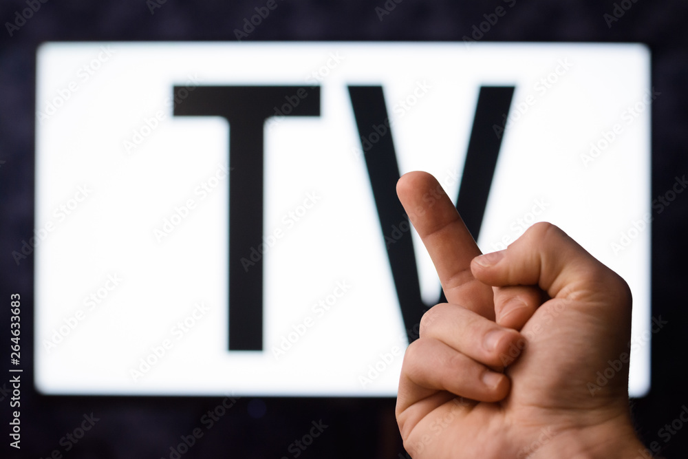 Angry man showing middle finger to a screen with inscription TV. Symbol ...