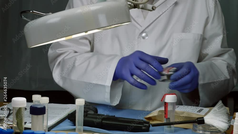Scientific police examining and making photos of a bullet cap in ...