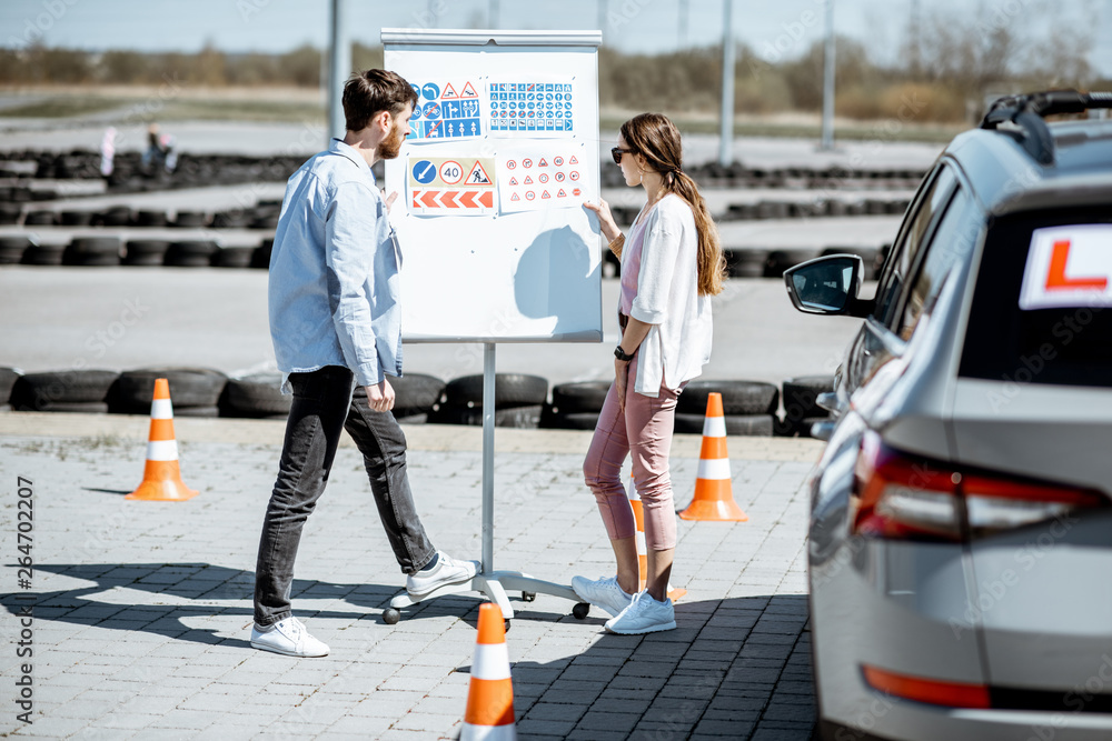 Male instructor showing traffic signs to a young female student ...